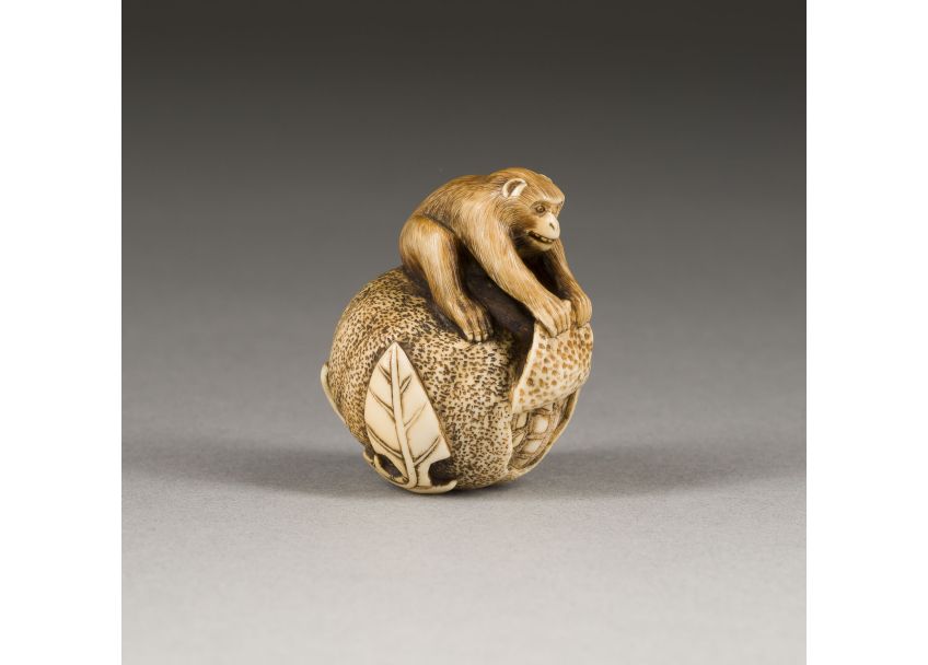 A finely carved netsuke featuring a monkey and an ivory mandarin orange